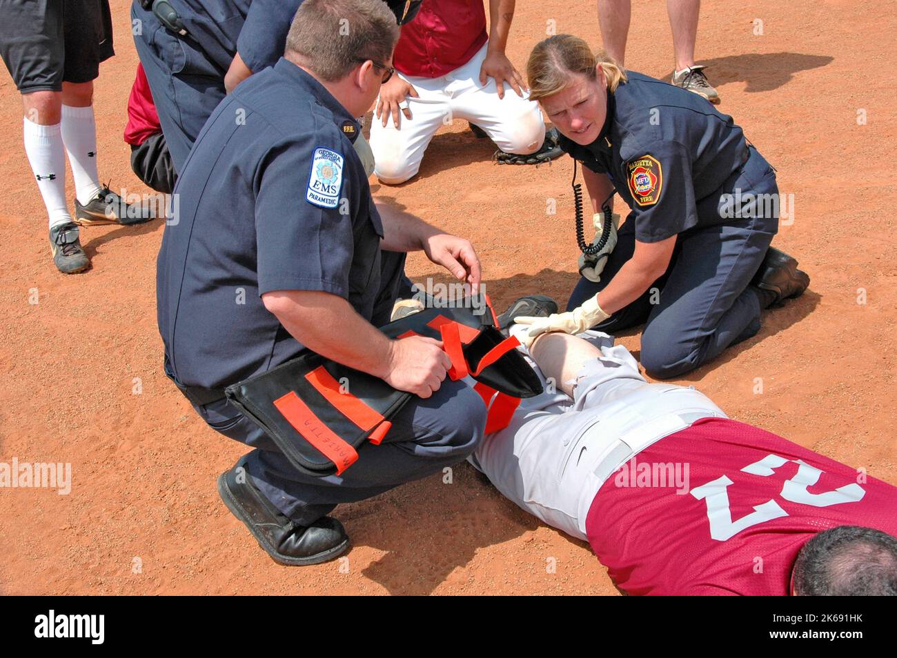 softball Player with broken leg is attended to by fire personal and ...