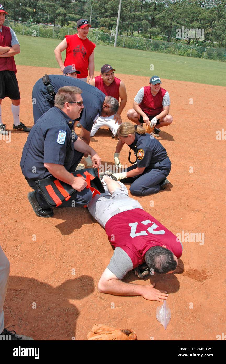 softball Player with broken leg is attended to by fire personal and ...