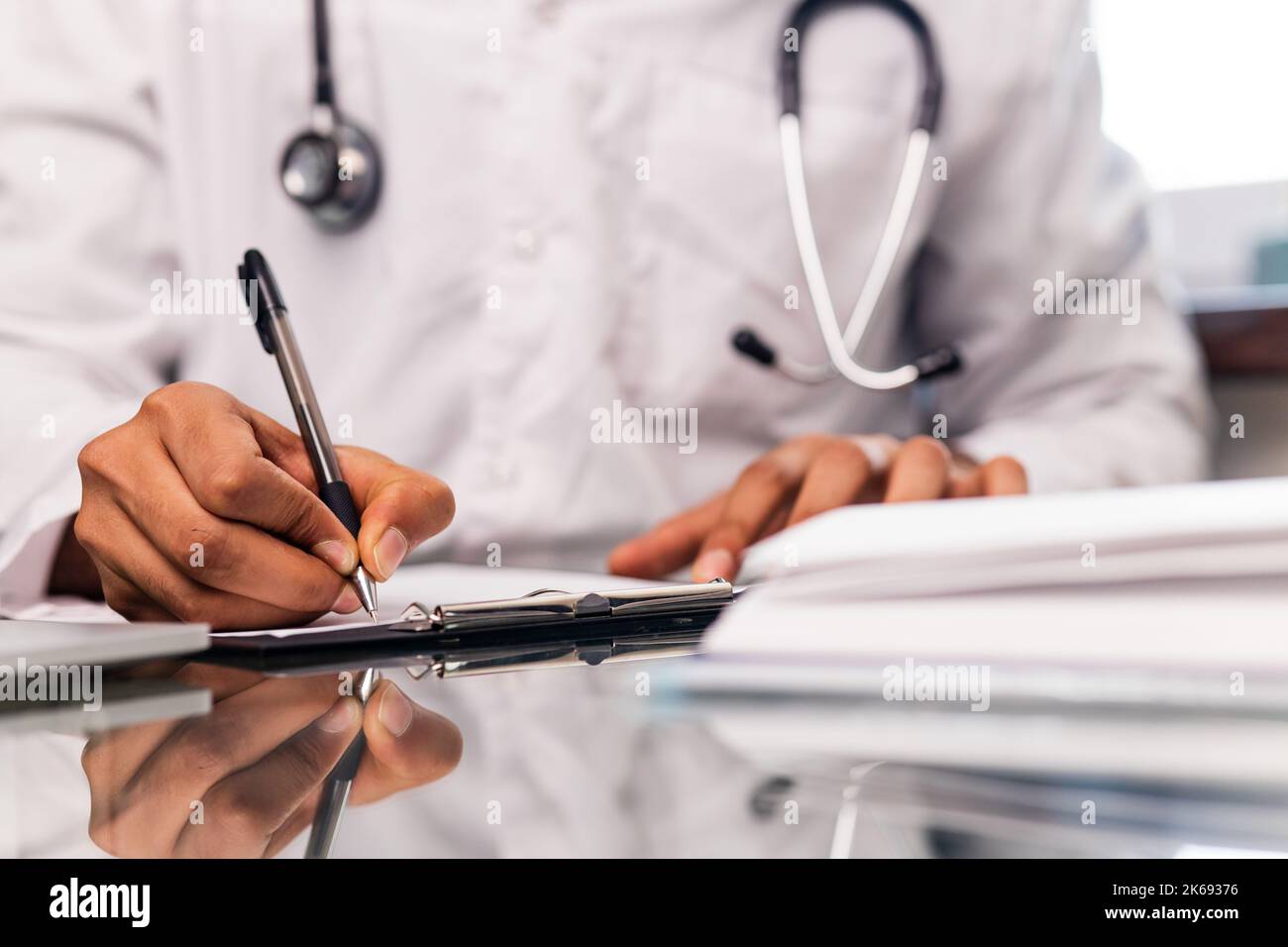 indian doctor wearing uniform taking notes in medical documents Stock ...