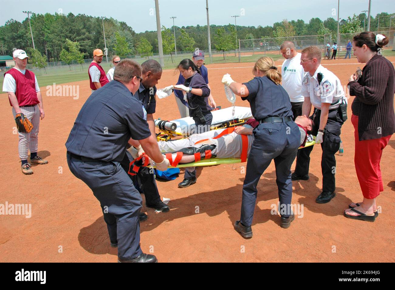 softball Player with broken leg is attended to by fire personal and ...