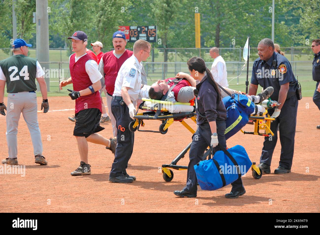 softball Player with broken leg is attended to by fire personal and ...