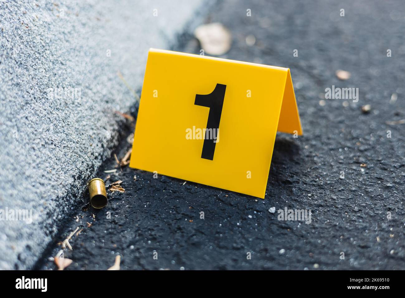 One yellow crime scene evidence marker on the street after a gun ...