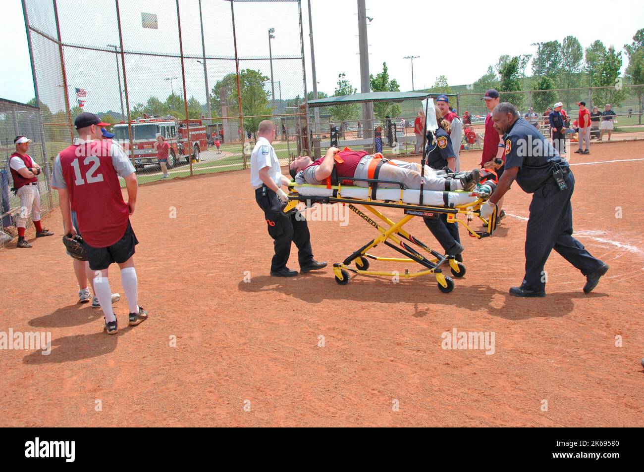 softball Player with broken leg is attended to by fire personal and ...