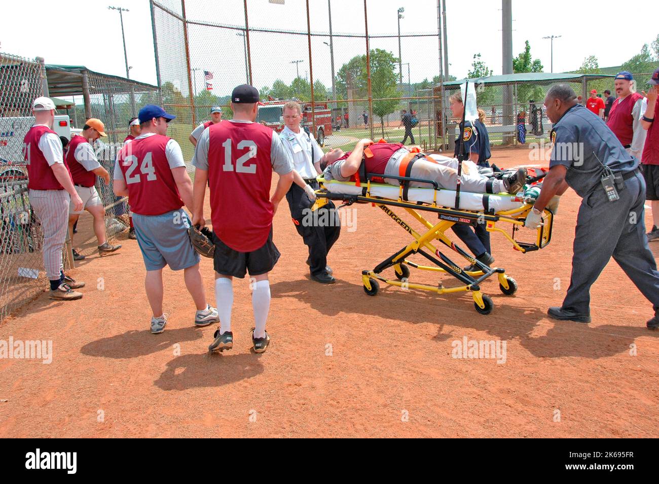 softball Player with broken leg is attended to by fire personal and ...