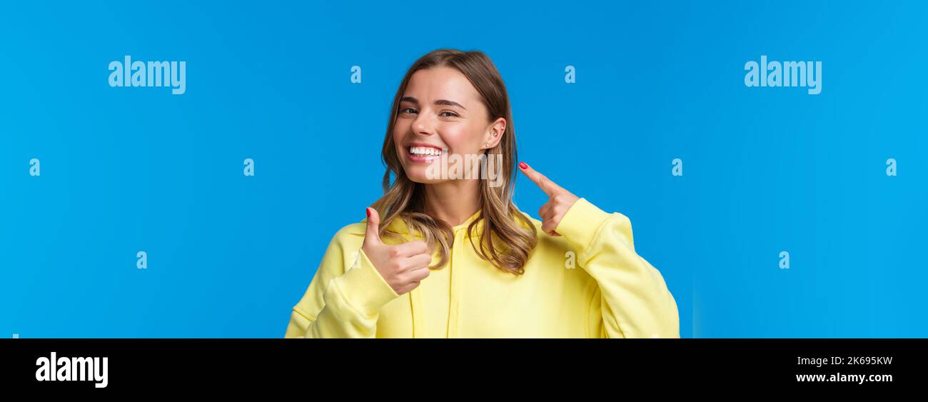 Cheerful and pleased, satisfied good-looking european female pointing ...