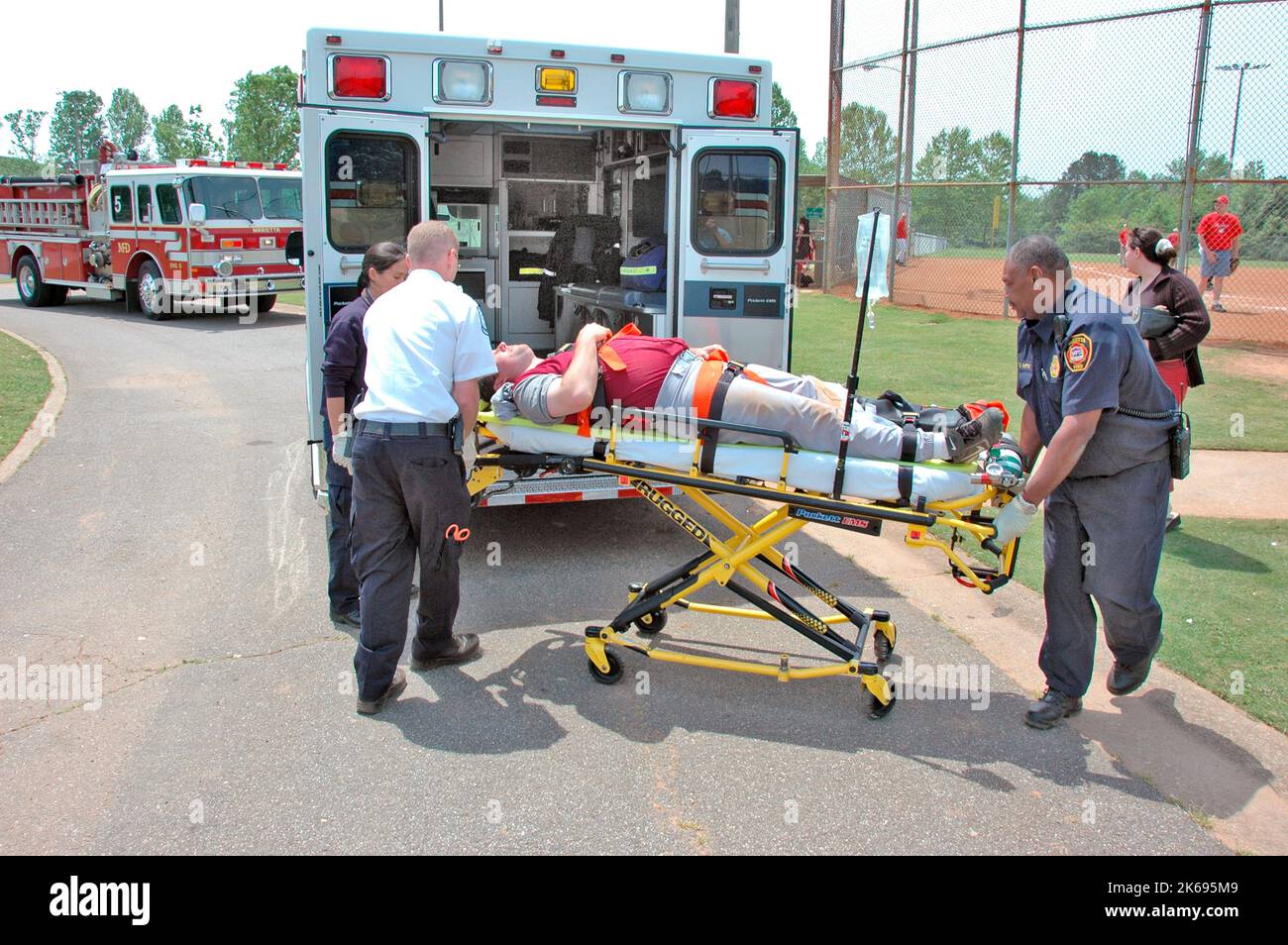 softball Player with broken leg is attended to by fire personal and ...