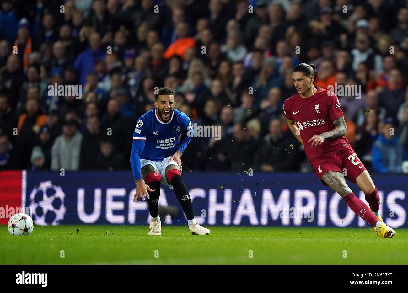 Rangers' Connor Goldson picks up an injury as he challenges Liverpool's ...