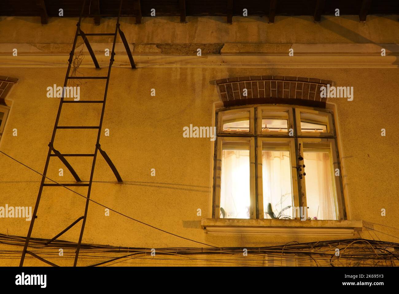 Window of old house viewed from outside with wind chimes and metal ...