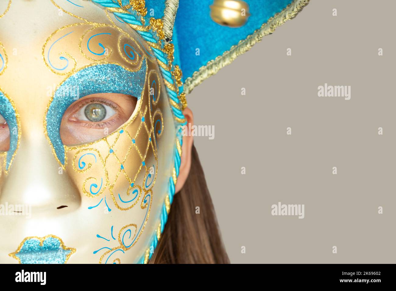 The face of a girl in a Venetian carnival mask on an isolated ...