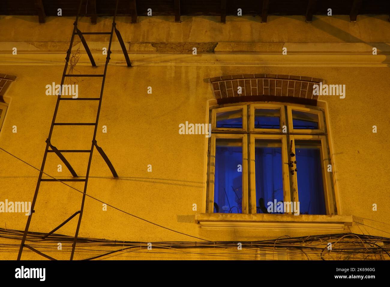 Window of old house viewed from outside with wind chimes and metal ...