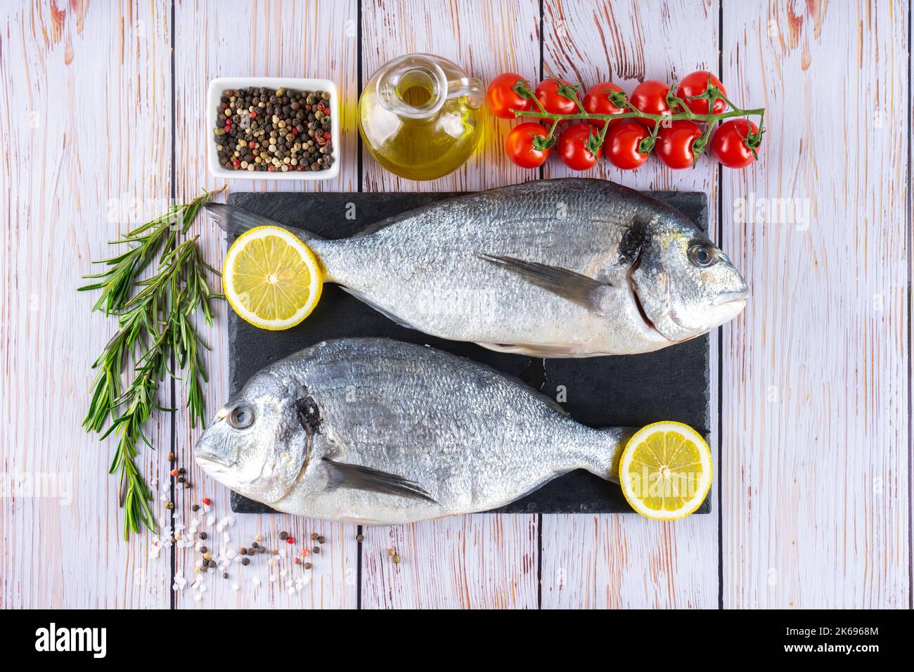 Dorado fish on white wooden background. Sea food with ingredients for ...
