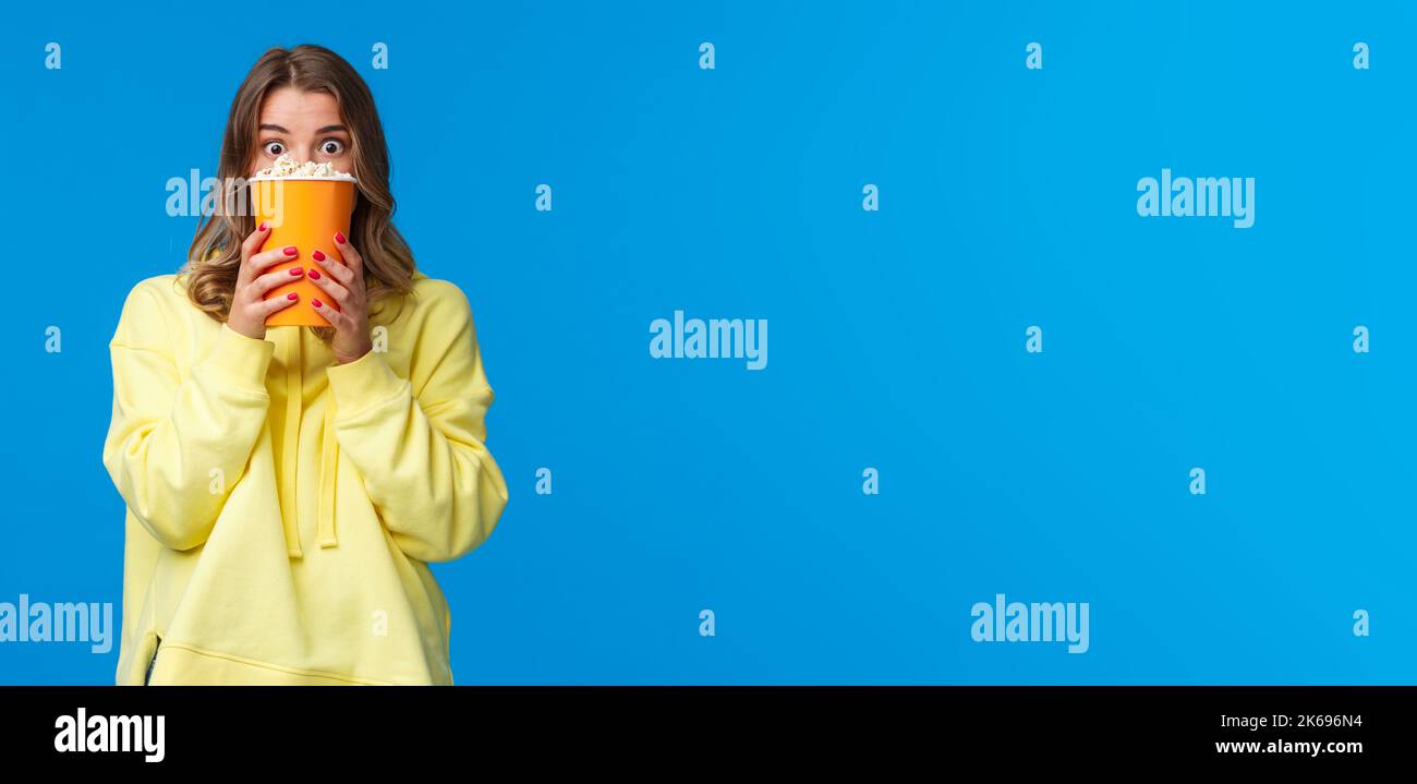 Leisure, fun and youth concept. Thrilled scared blond girl hiding ...