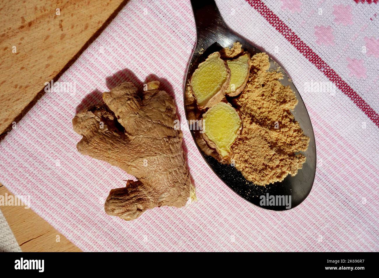 Ginger root and spoon with ginger slices and powder on cotton napkin on ...