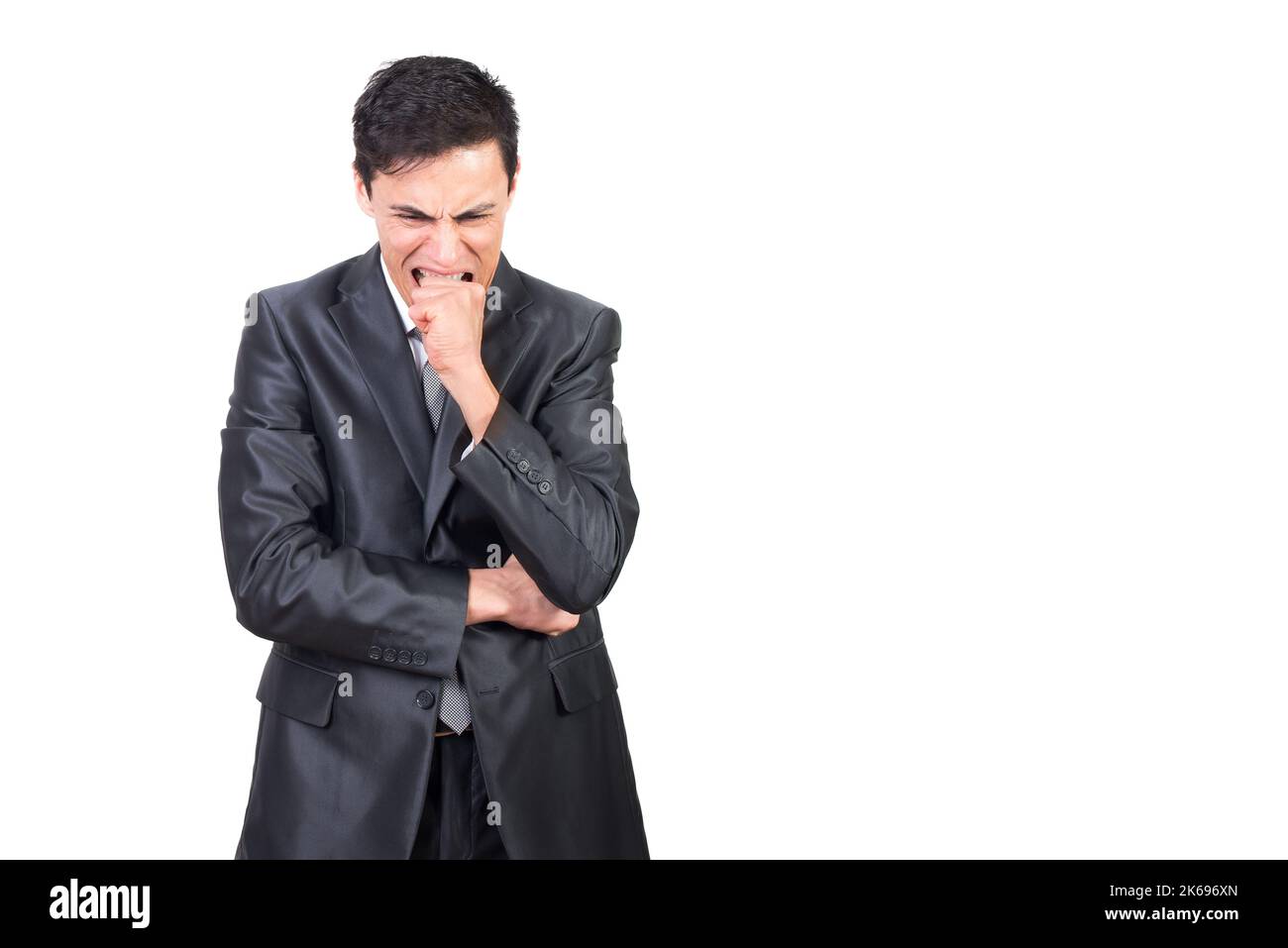 Excited man biting hand while expressing nervous state Stock Photo - Alamy