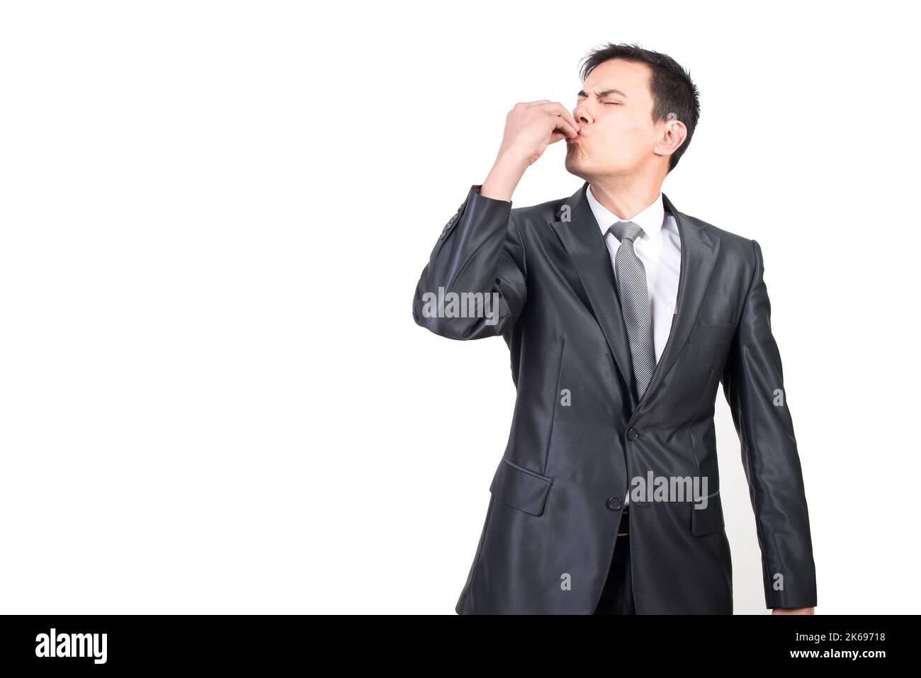 Expressive man in black suit showing delicious gesture Stock Photo - Alamy