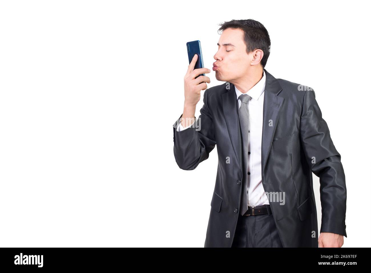 Man in suit kissing smartphone in studio Stock Photo - Alamy