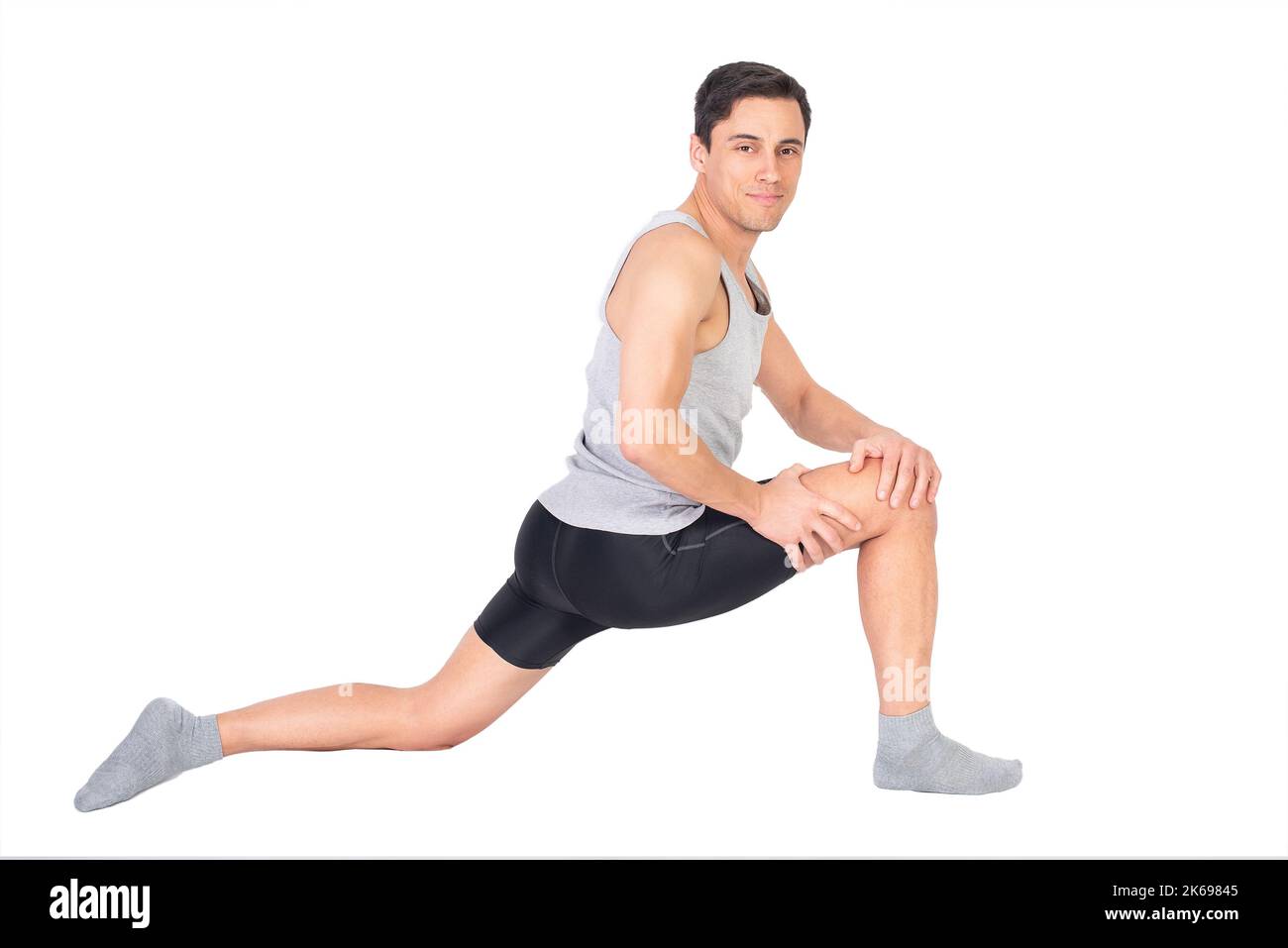 Positive sportsman doing stretching exercise in studio Stock Photo - Alamy