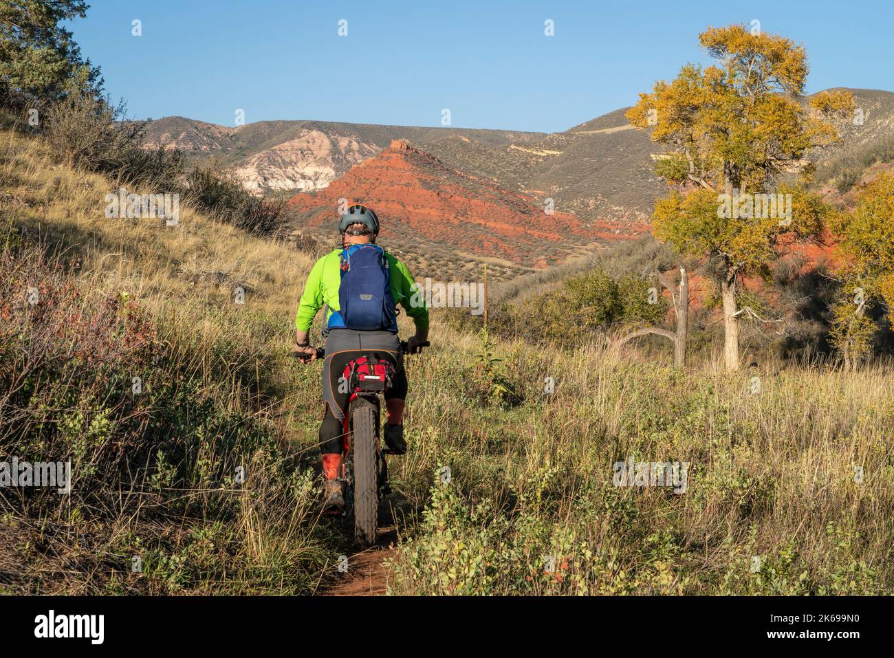 male cyclist is riding a fat mountain bike on a single track trail in ...