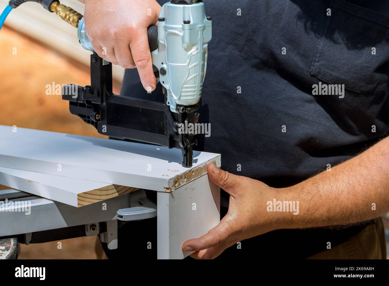 Carpenter connects assembly for wood boards with nails with pneumatic ...