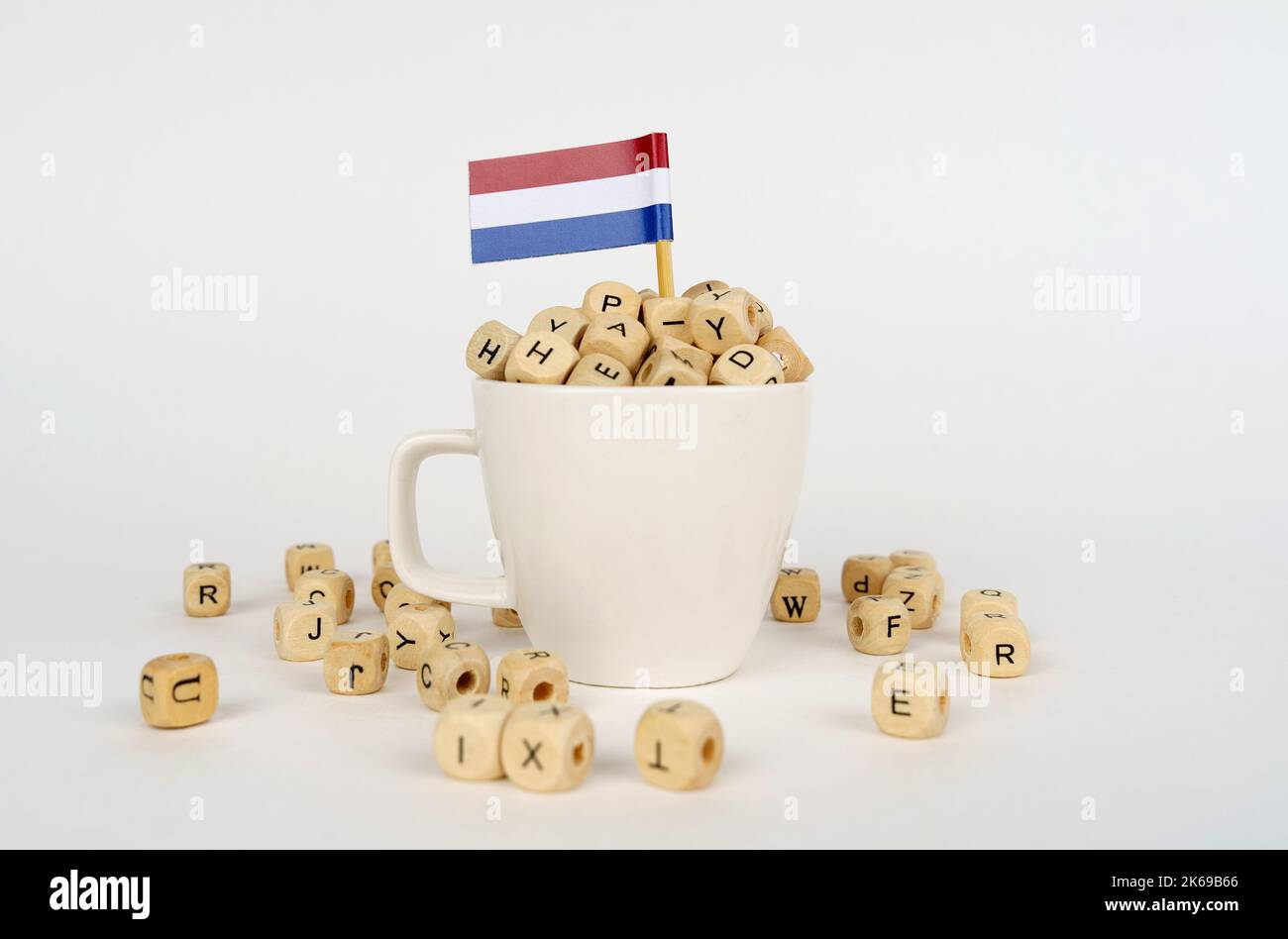 The flag of the Netherlands sticks out of a cup with dice on which ...