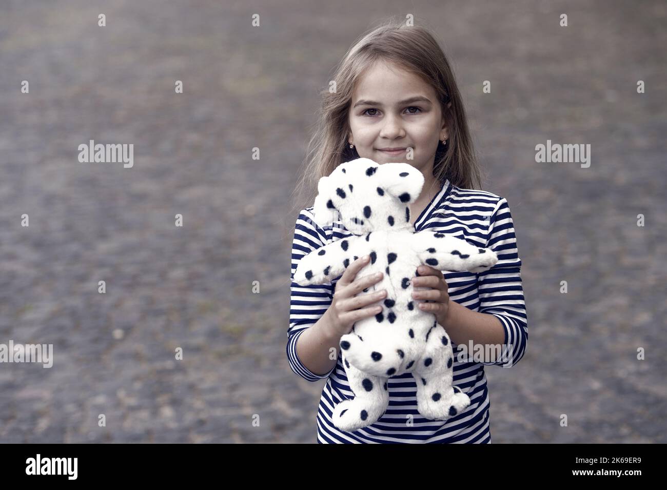Pick the best. Happy girl play with toy dog outdoors. Toy shop. Games ...