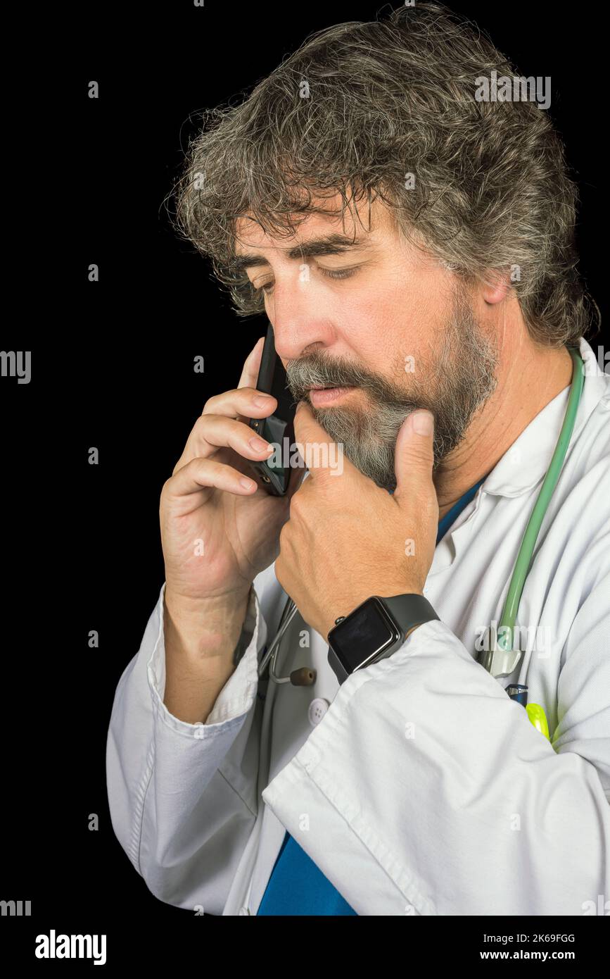 mature doctor with a beard dressed in a blue surgical suit and a white ...