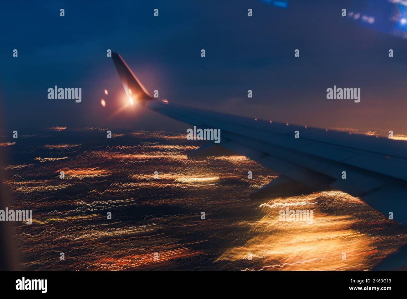 An airplane wing on the background of blurred lights at night Stock ...