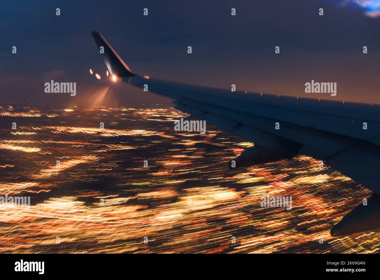 An airplane wing on the background of blurred lights at night Stock ...