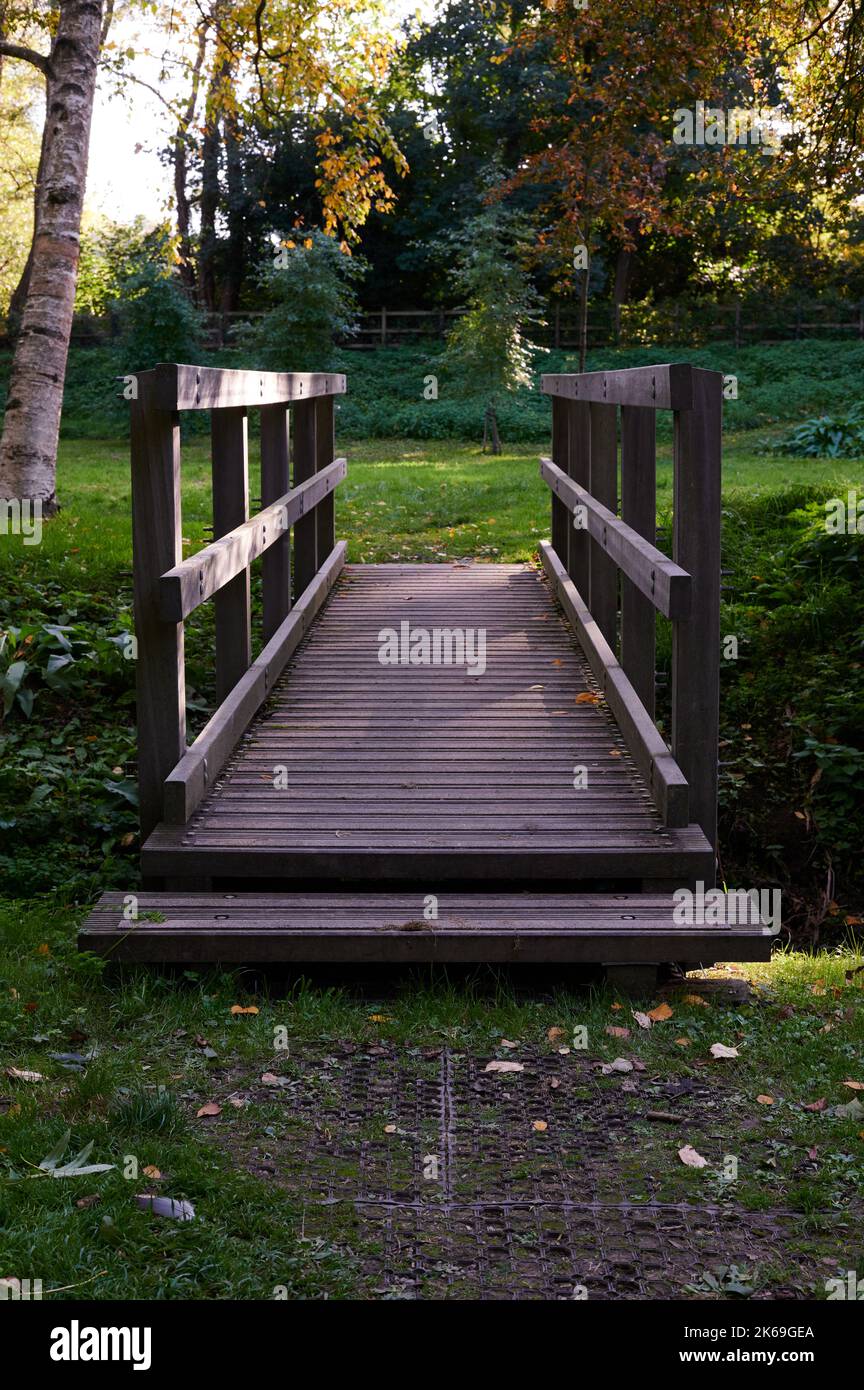 Small wooden footbridge in park with green grass Stock Photo - Alamy