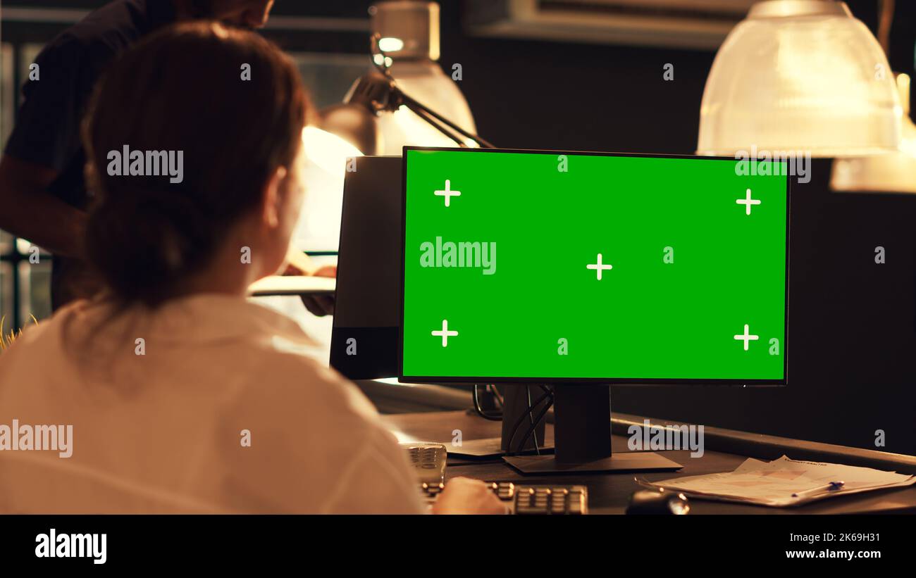 Woman working with greenscreen template on computer, looking at blank ...