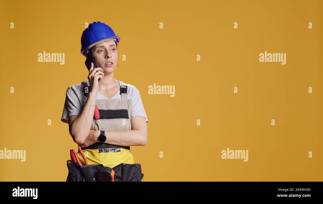 Portrait of empowered handywoman answering phone call to work on ...