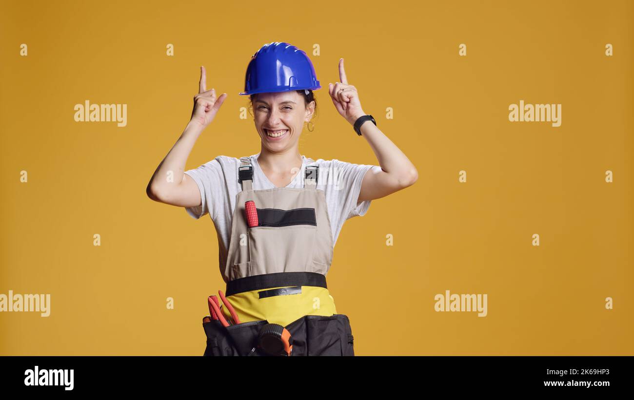 Powerful handywoman pointing up to advertise upwards direction and work ...