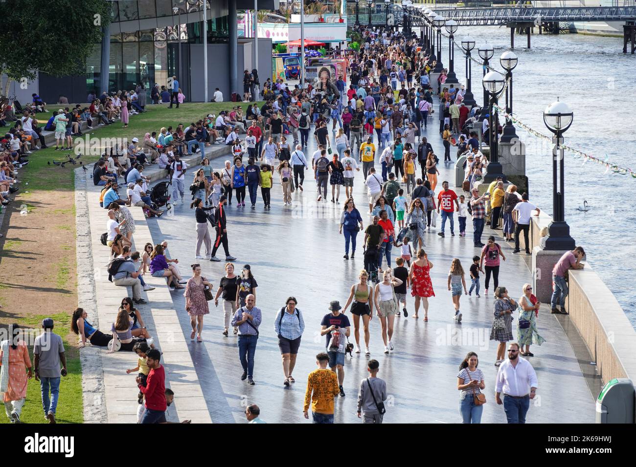People enjoying sunny day at the Queen's Walk promenade in London ...