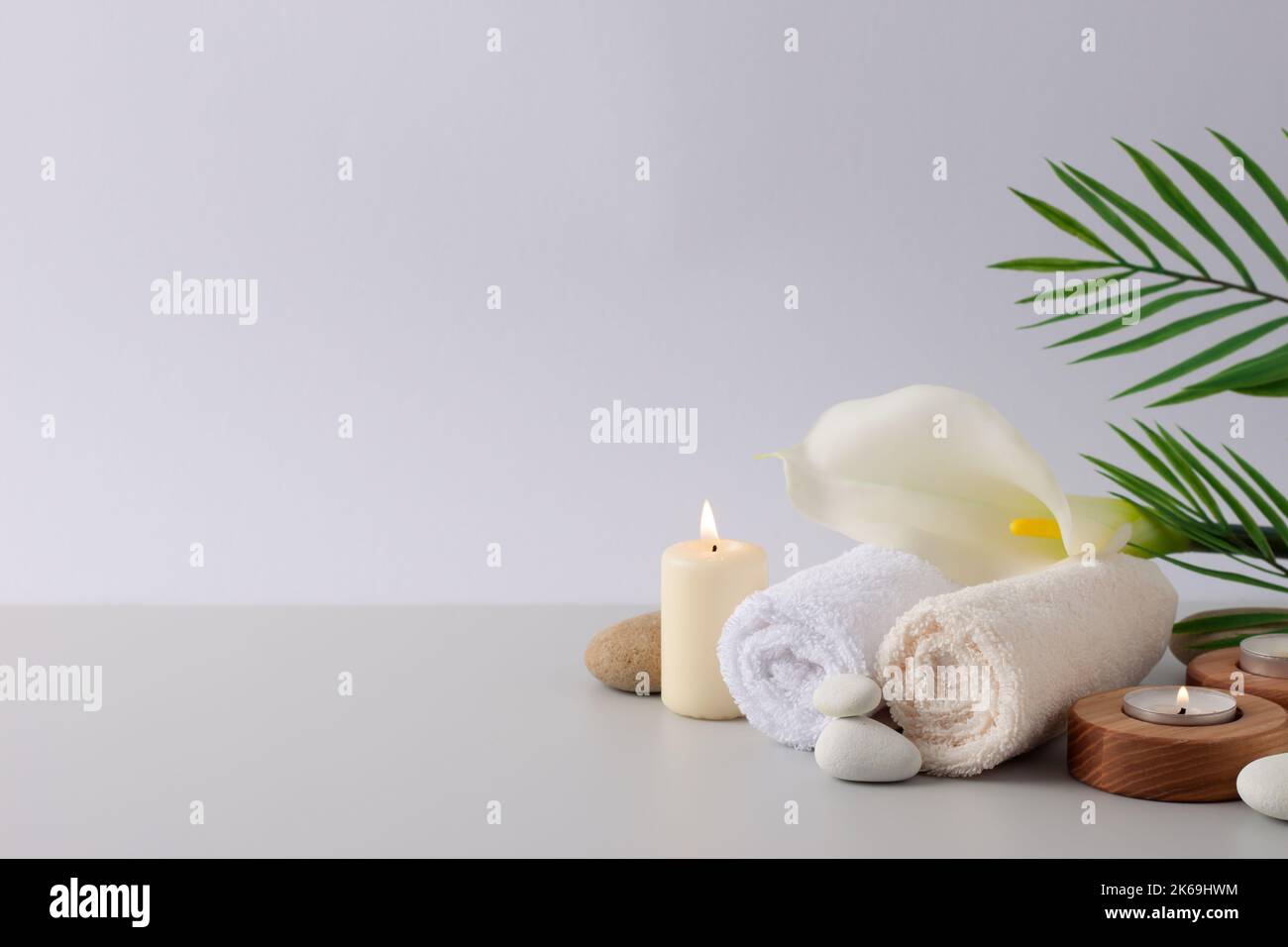 Spa treatment with candles, towel and flowers on white background ...