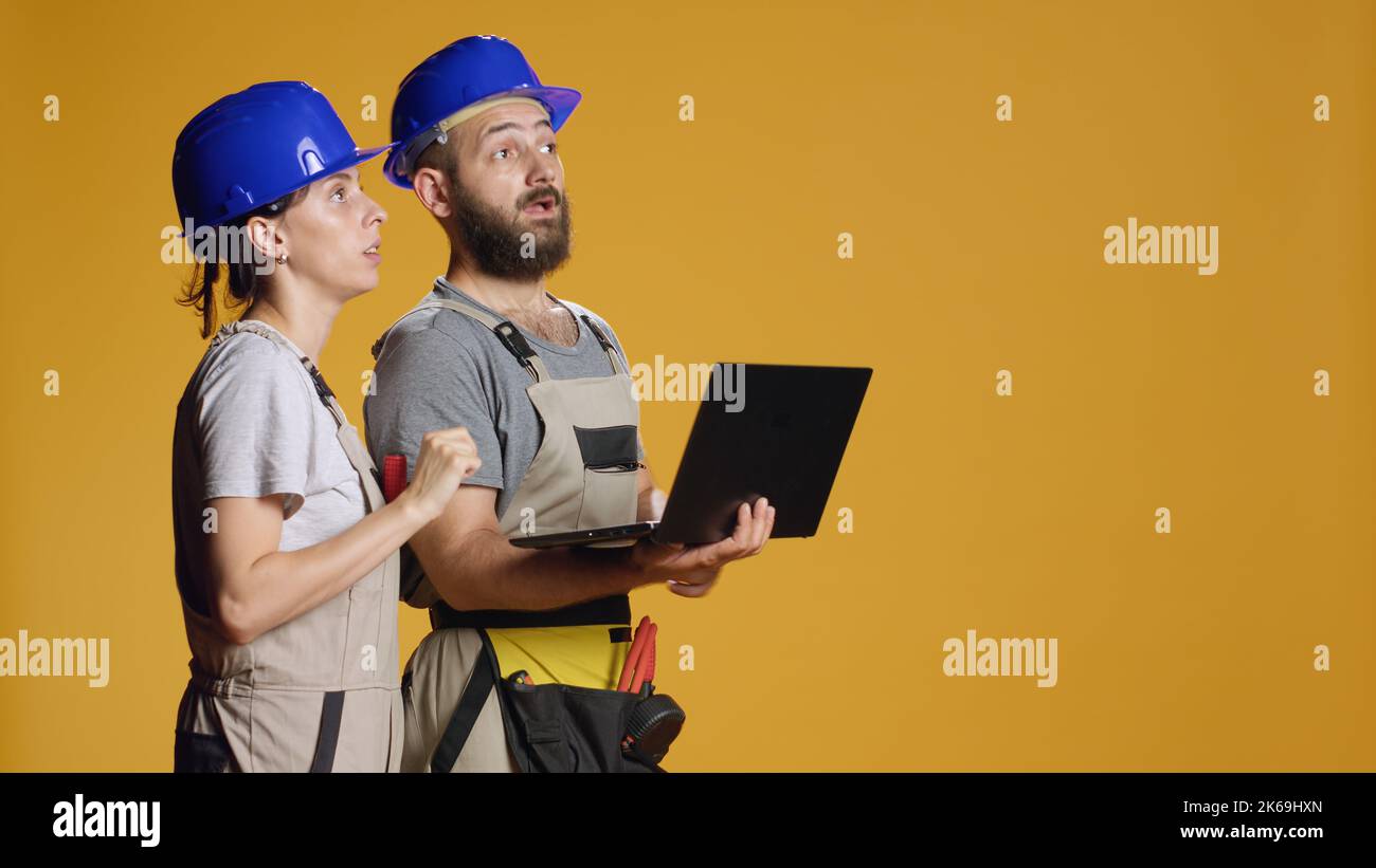 Man and woman contractors using laptop to do rebuilding measurement ...