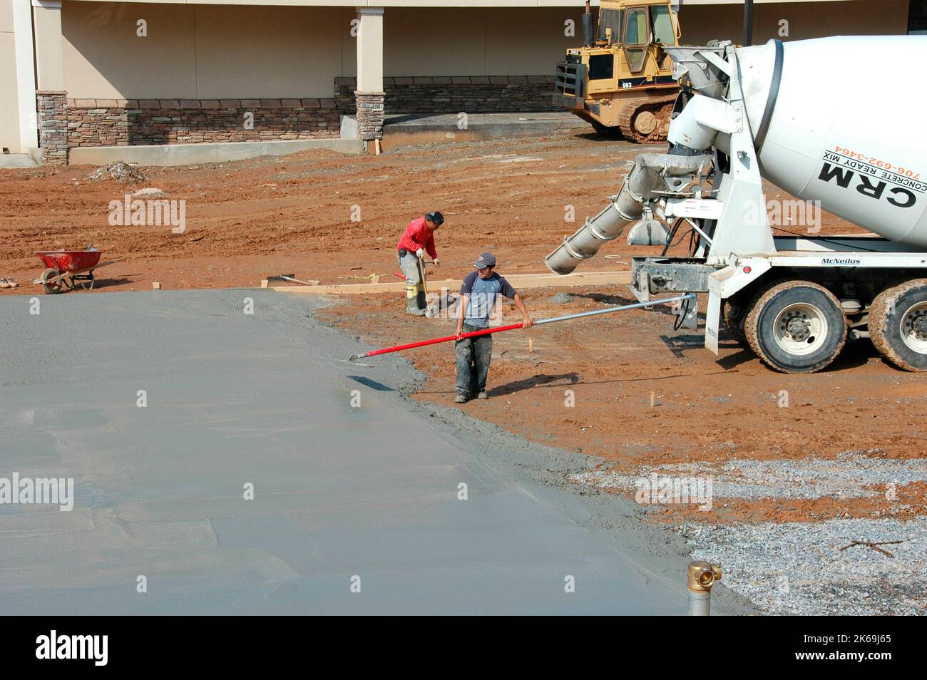 Pouring cement from truck at commercial business site being build by ...