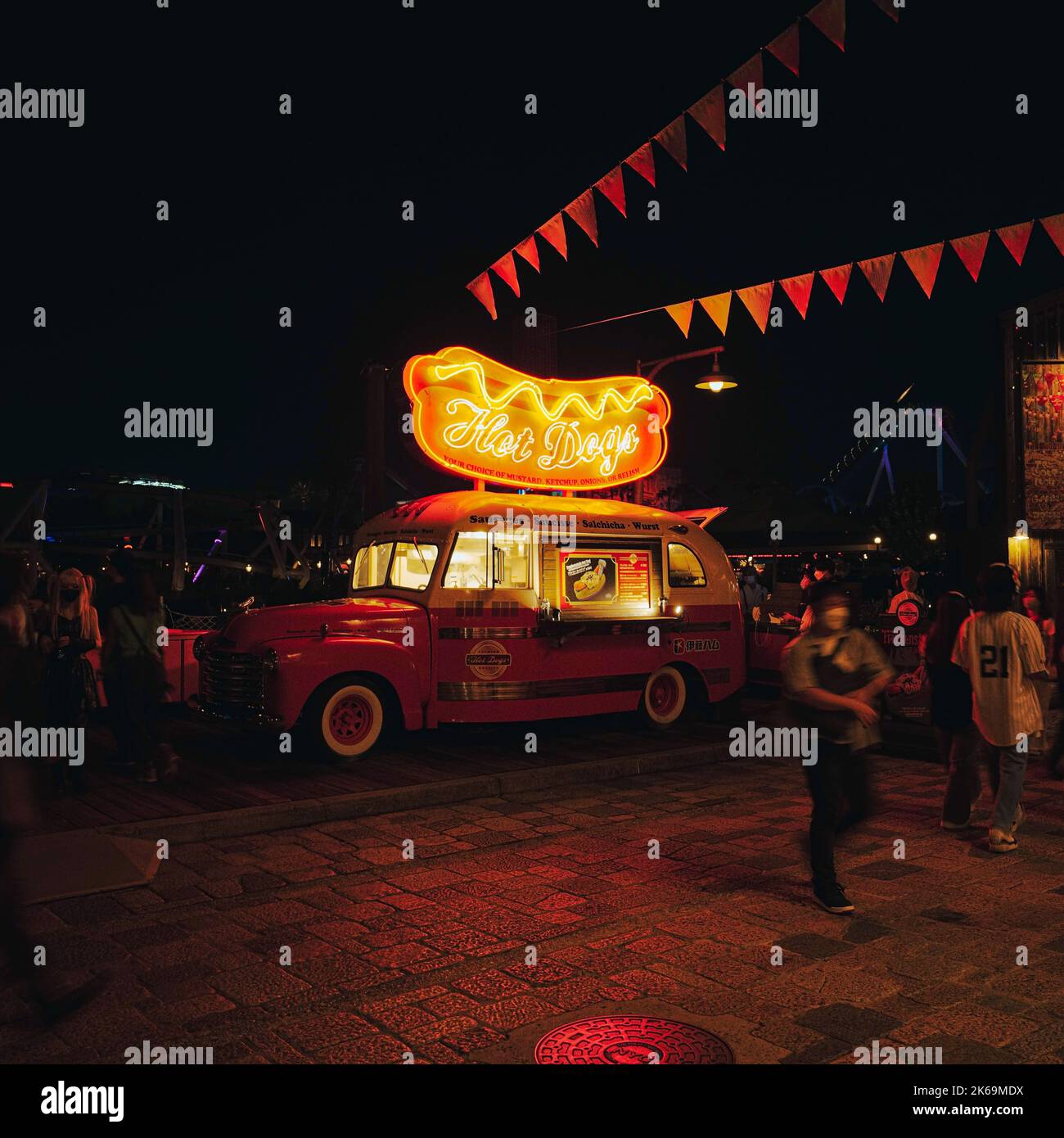 A fast-food vehicle on the street at night illuminated with lights ...