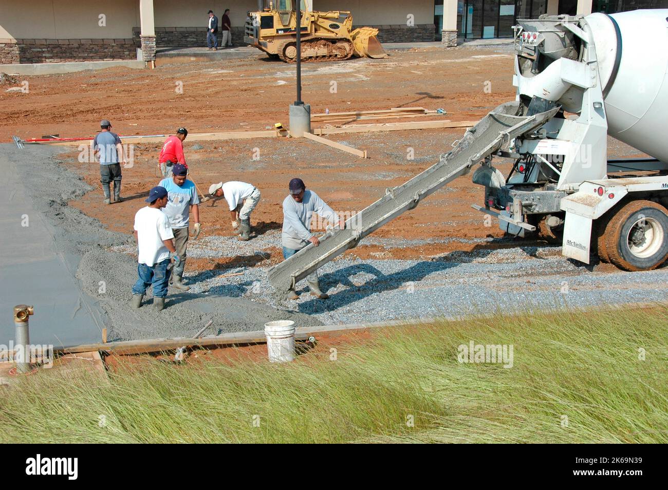 Pouring cement from truck at commercial business site being build by ...