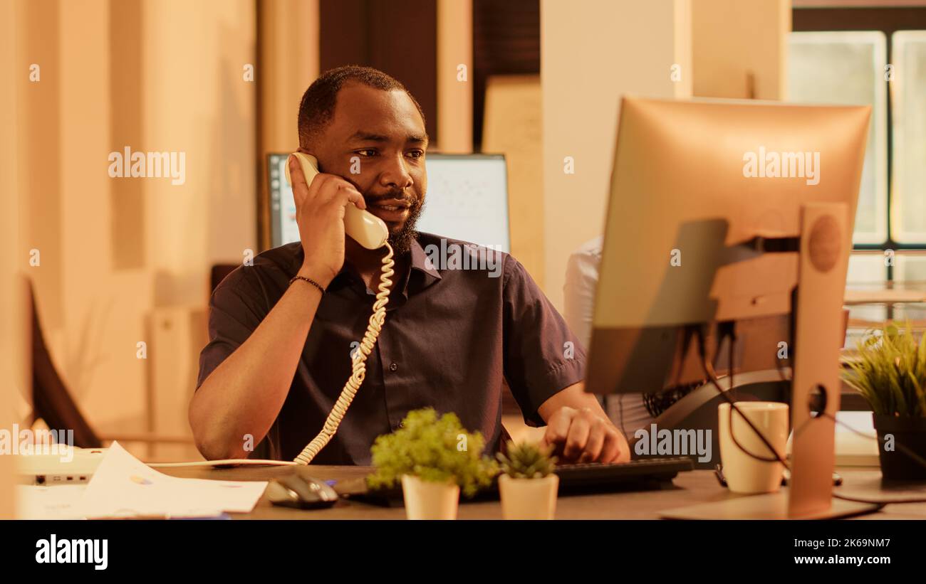 Executive assistant answering landline phone call in office with big ...