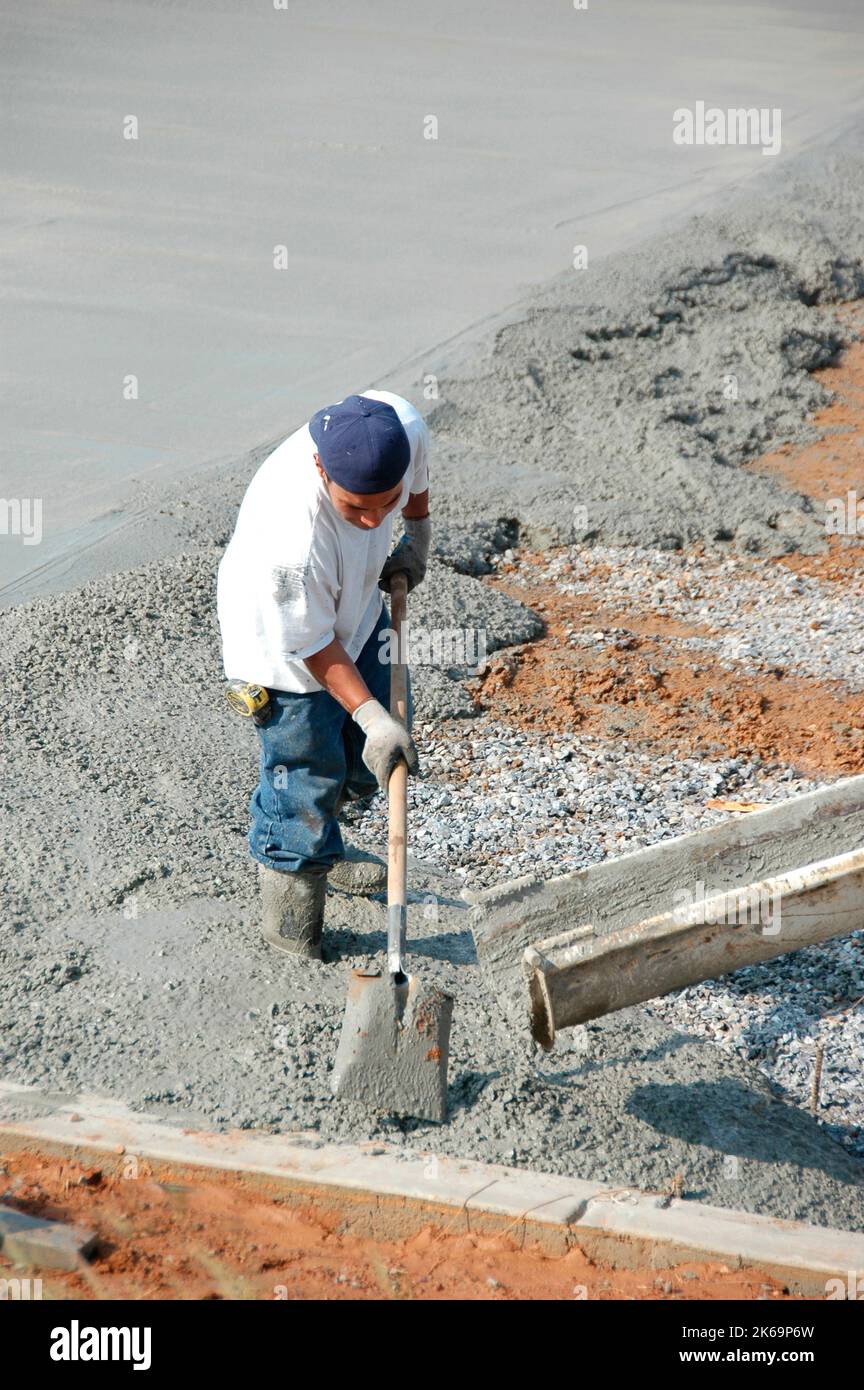 Pouring cement from truck at commercial business site being build by ...