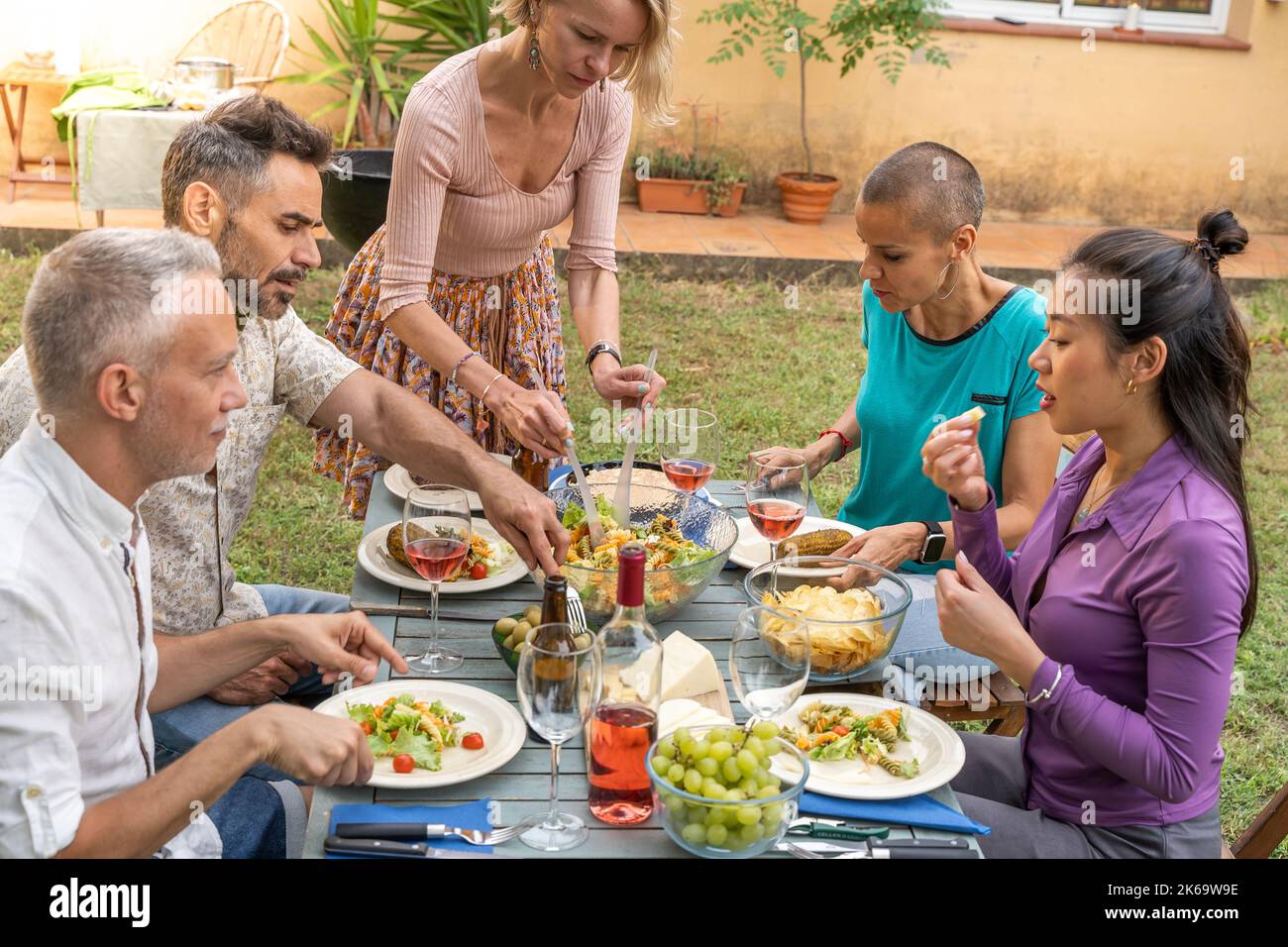 Diverse friends gathering around table hi-res stock photography and ...
