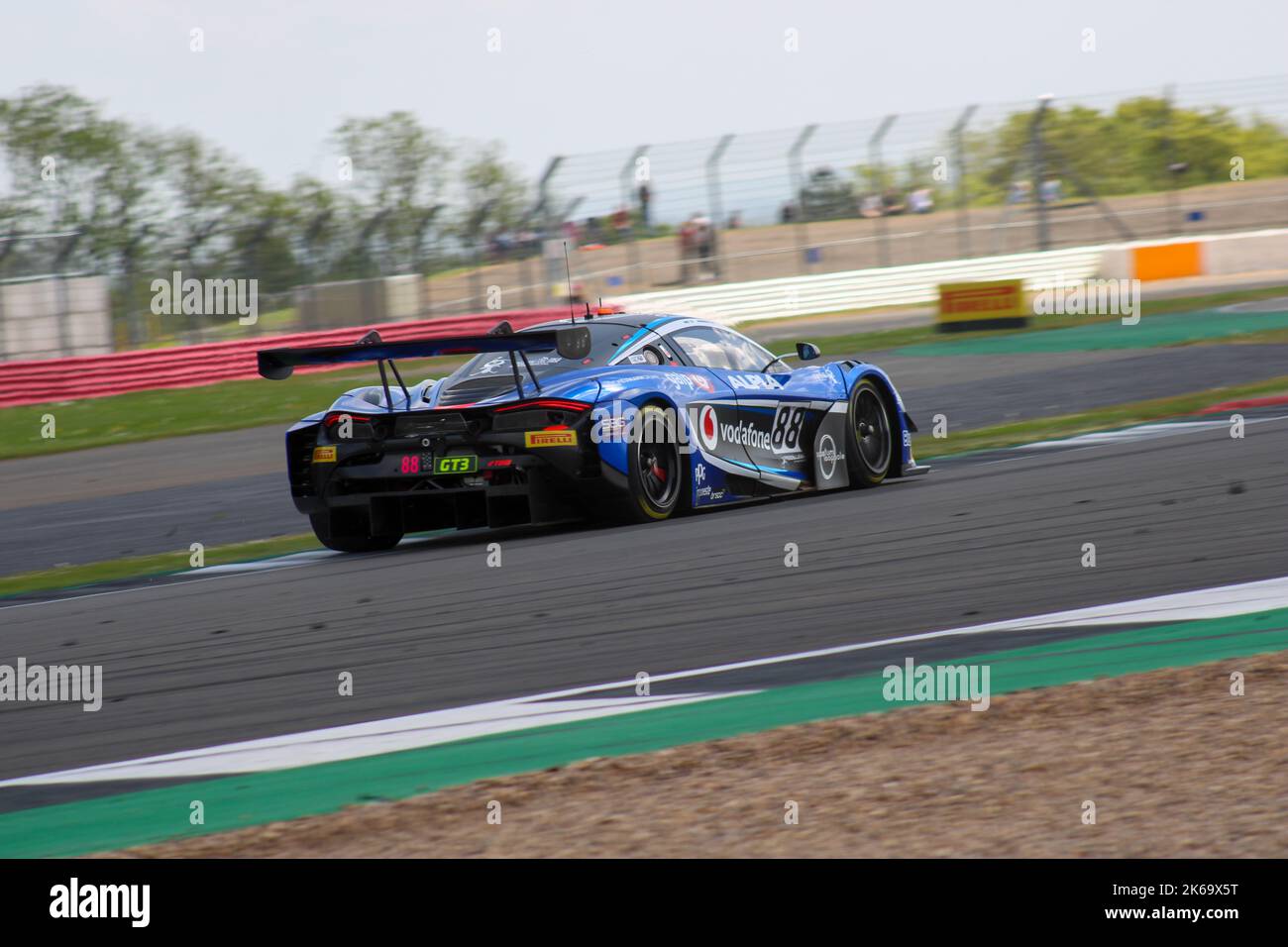 A decorated blue racing car driving on a circuit track for a race Stock ...