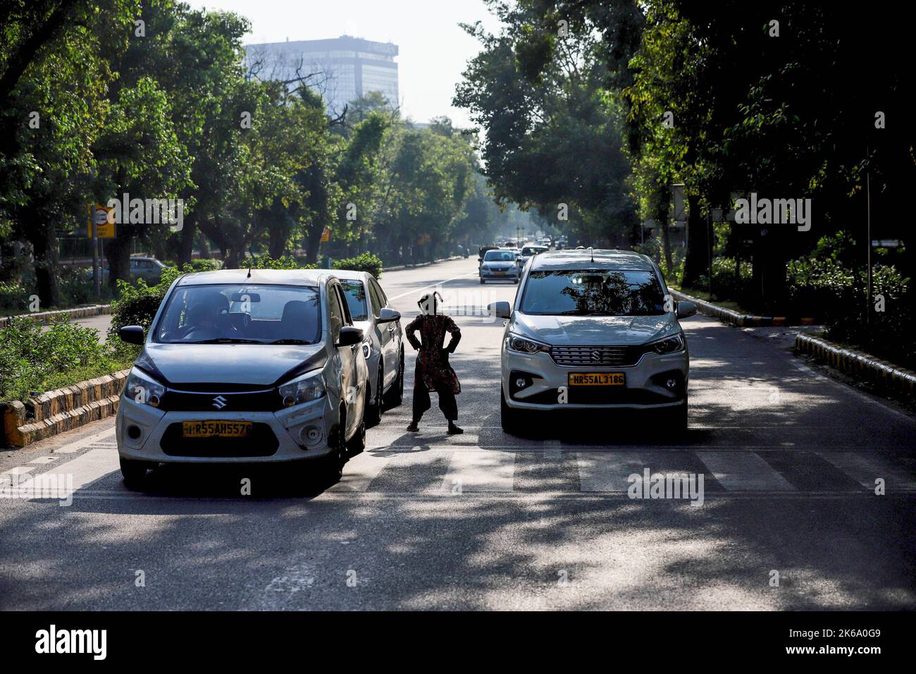 A poor girl child performs acrobatics in front of vehicles at a traffic ...