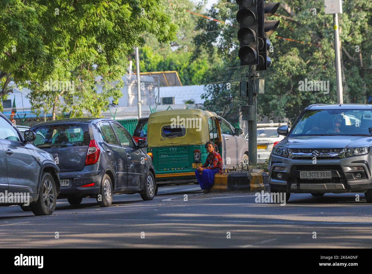 A poor girl child rests after performing acrobatics for alms in front ...