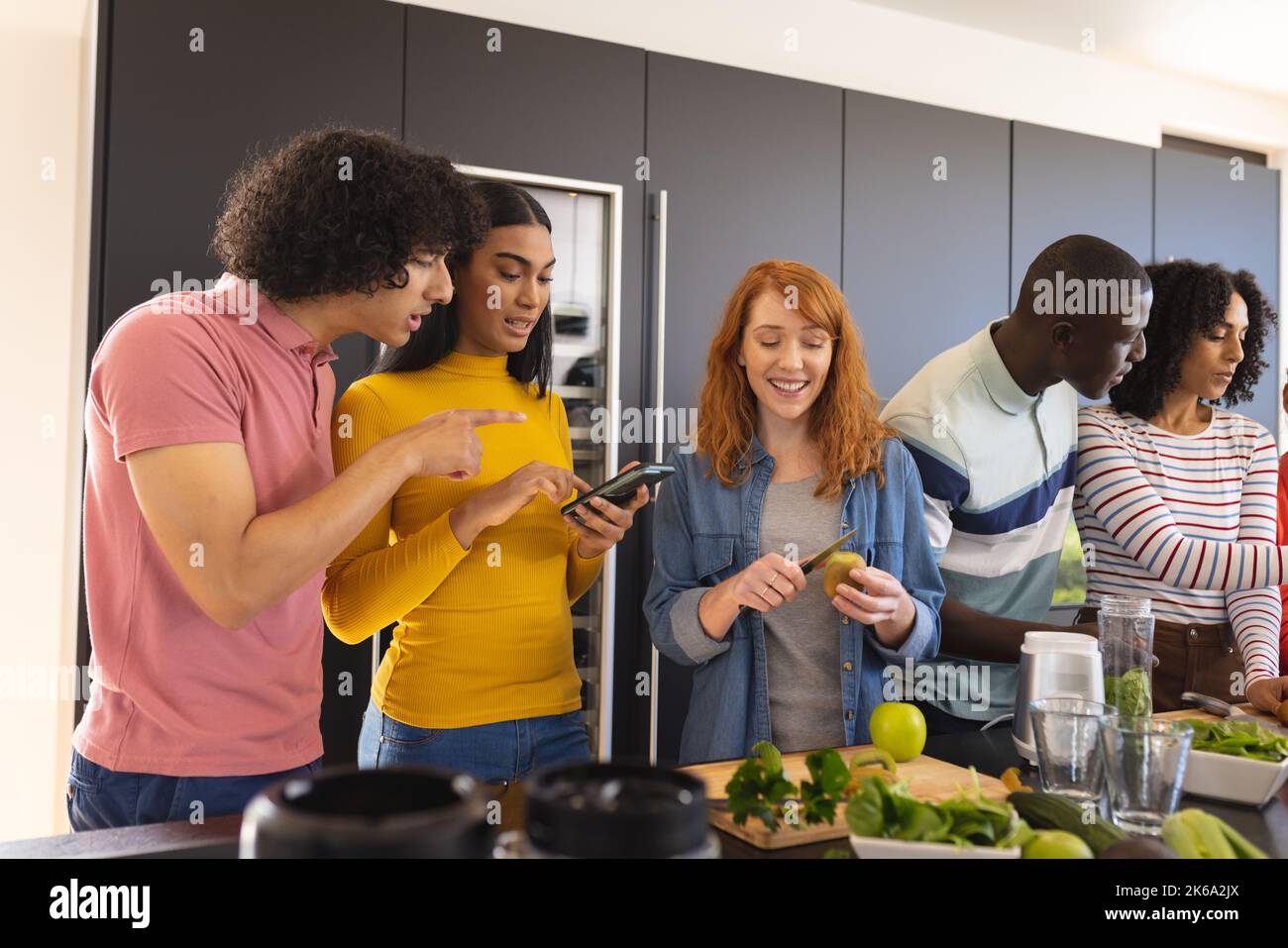 Happy diverse friends cooking together and smiling in kitchen Stock ...