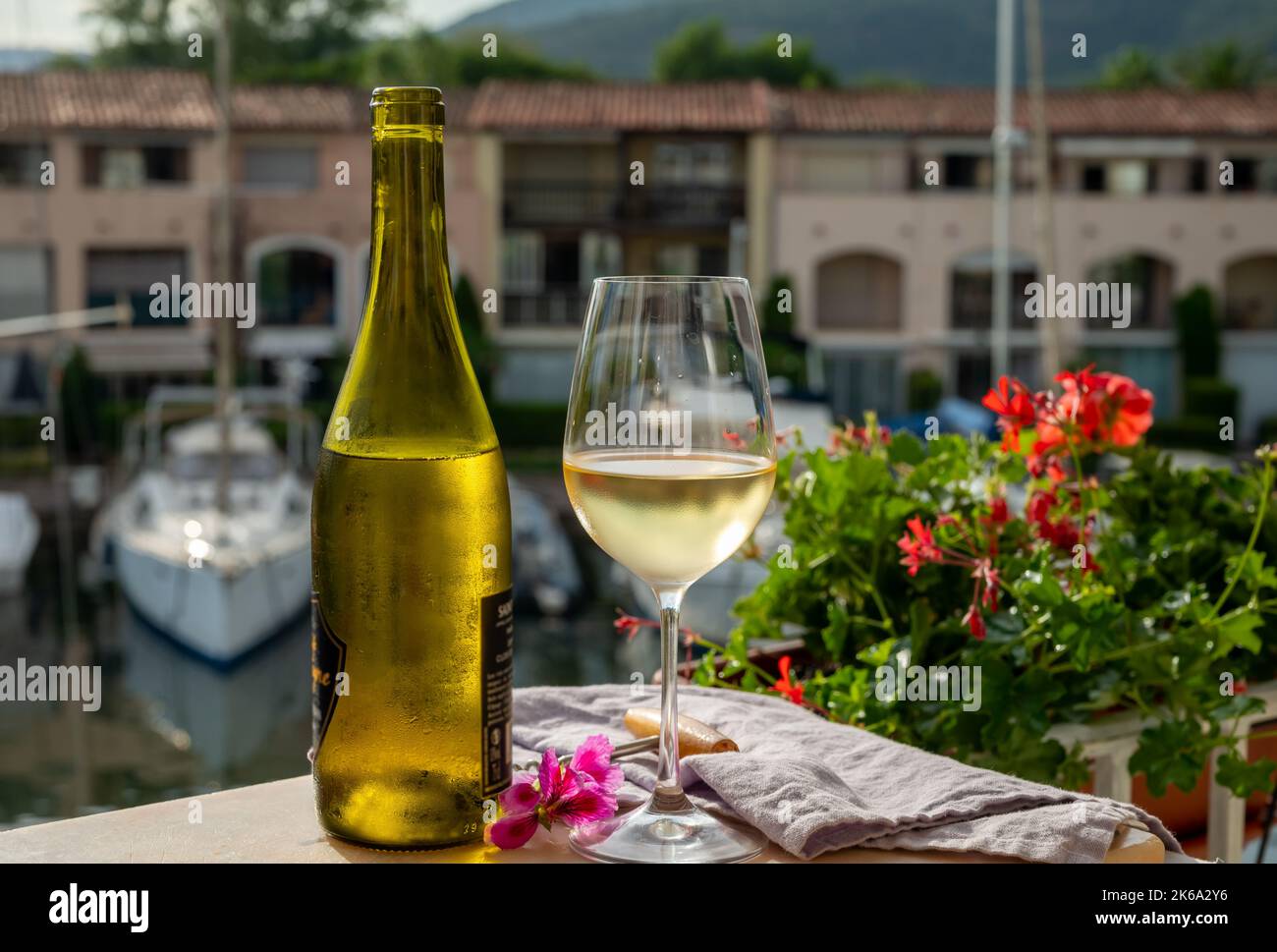 Drinking of cold white wine with view on yacht harbour of Port Grimaud ...