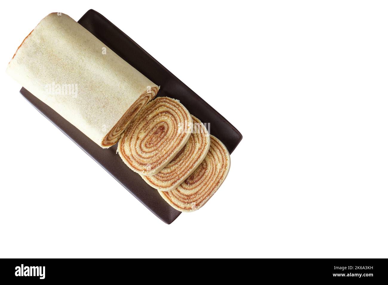 Sliced bolo de rolo (roll cake) on a brown plate. Brazilian traditional ...