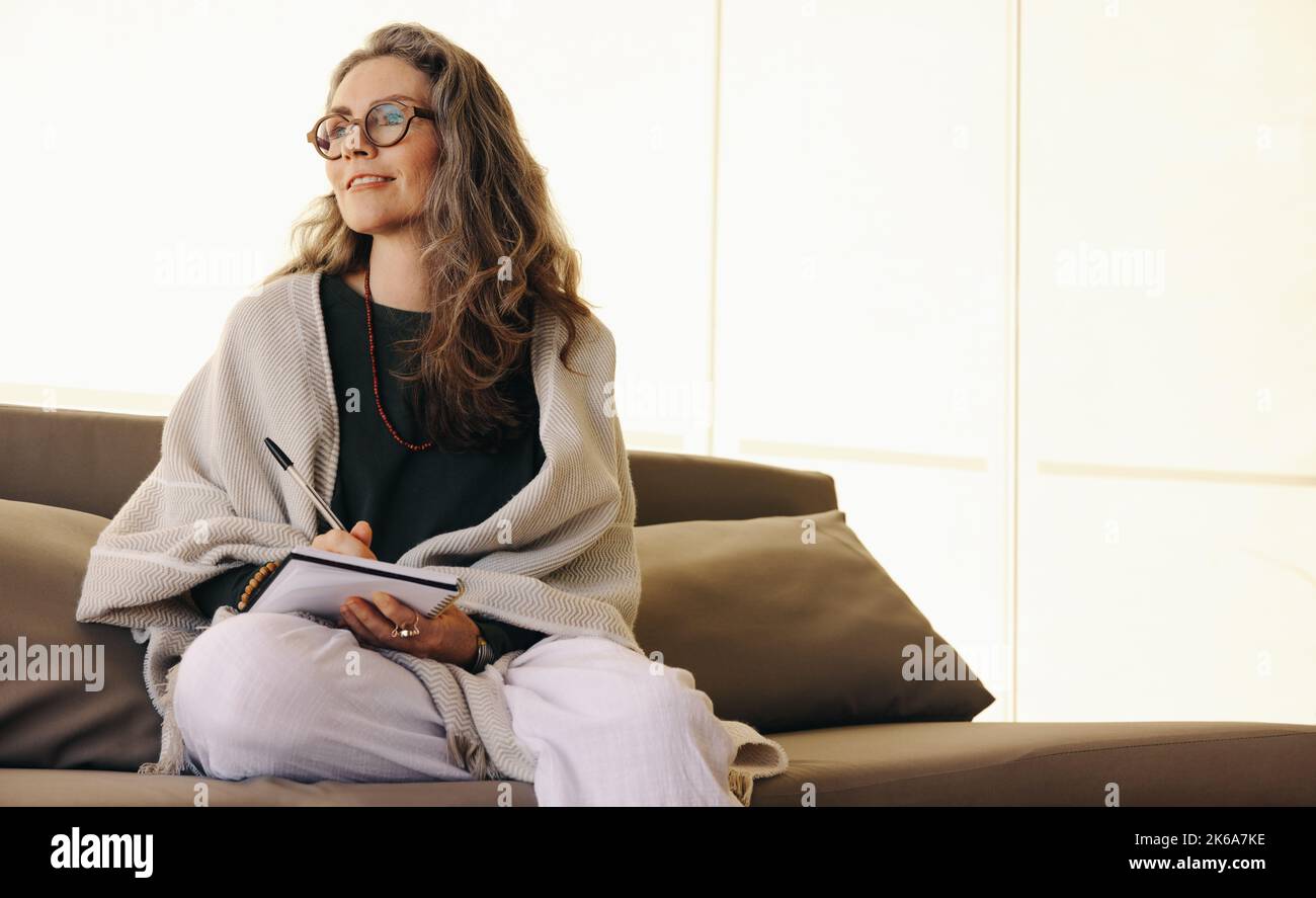 Journaling and self-awareness. Mature woman looking away thoughtfully ...