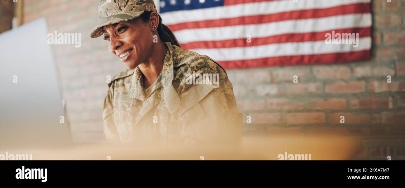 Cheerful female soldier smiling while video calling her family on a ...