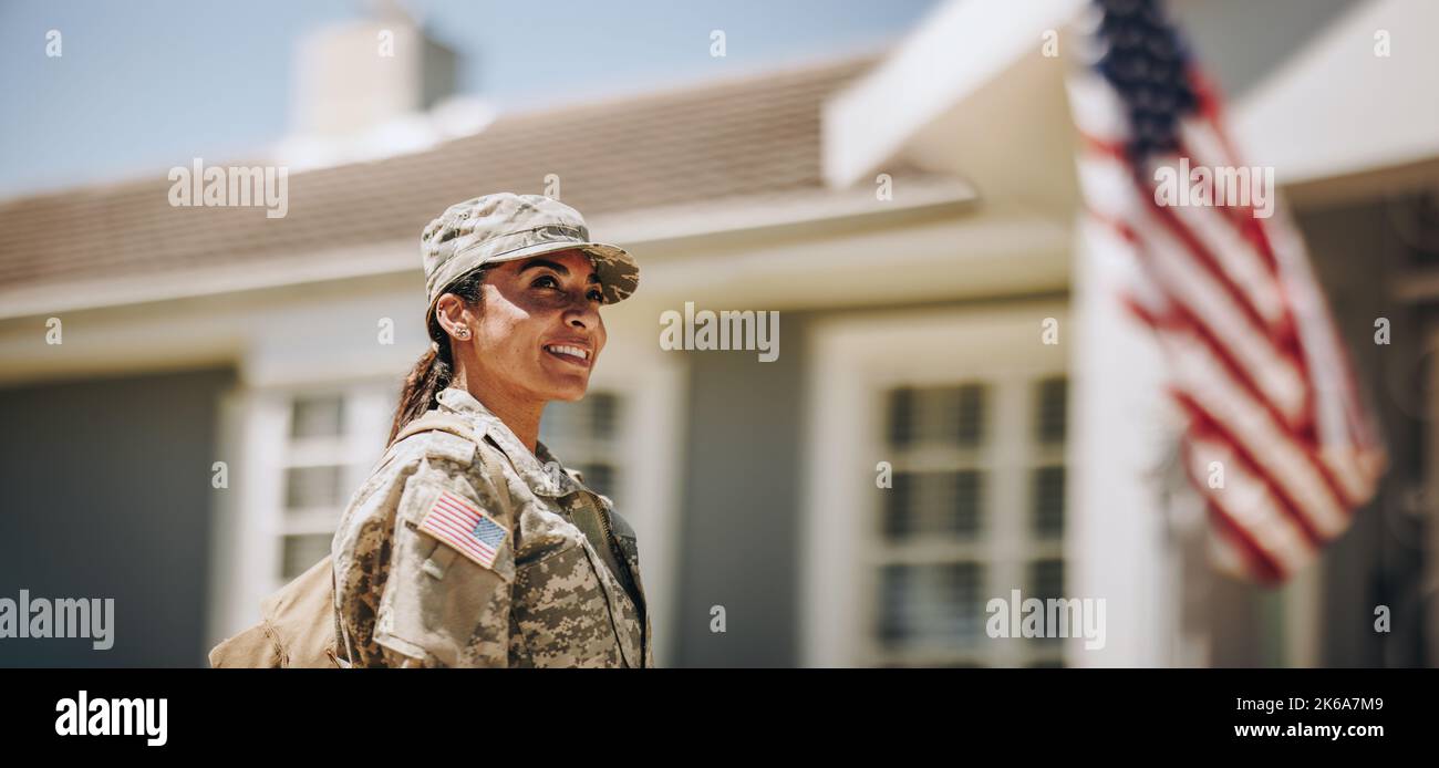 Happy female soldier looking away with a smile while standing outside ...